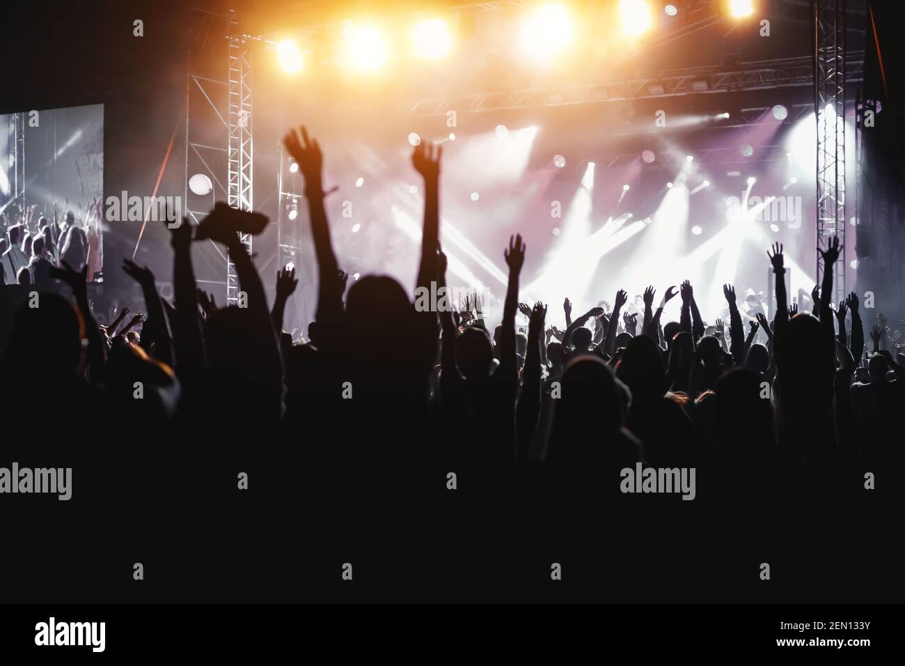 People with raised hands, silhouettes of concert crowd in front of ...
