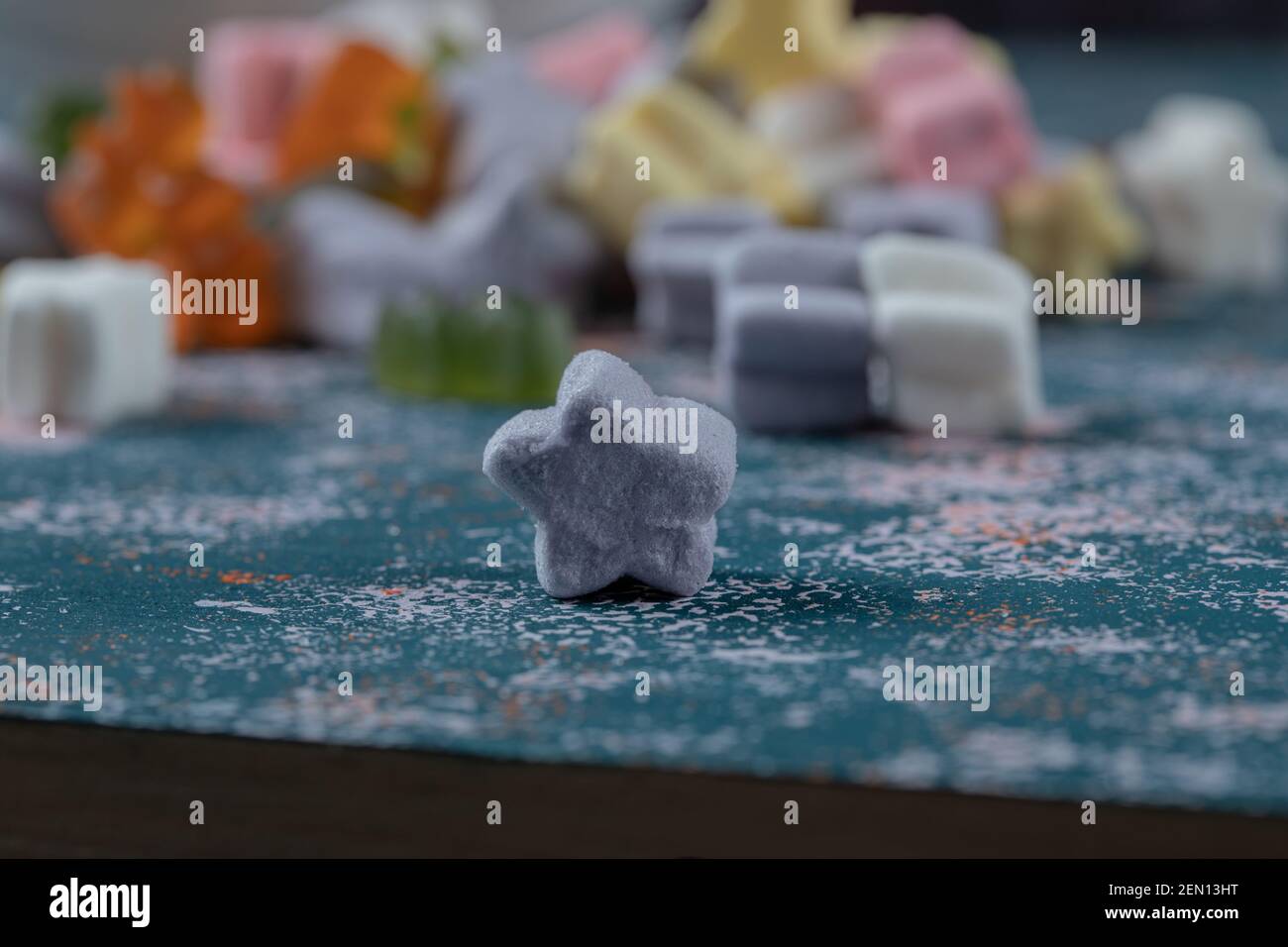 Small blue star shape marshmallow on the ground Stock Photo - Alamy