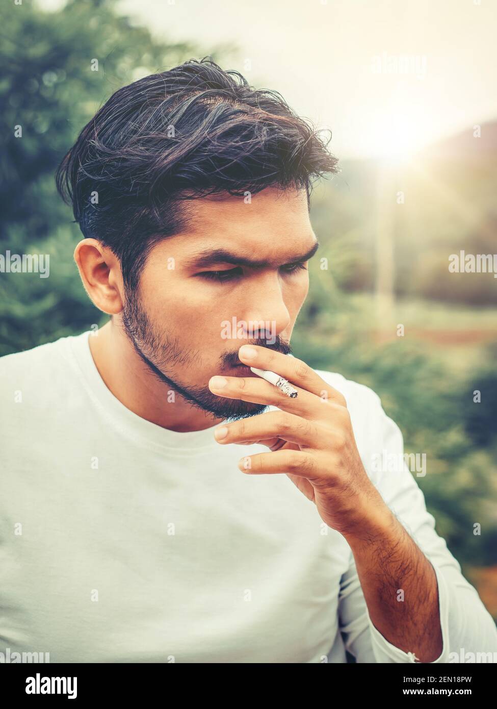 Young man smoking cigarette in the outdoors and nature background Stock ...