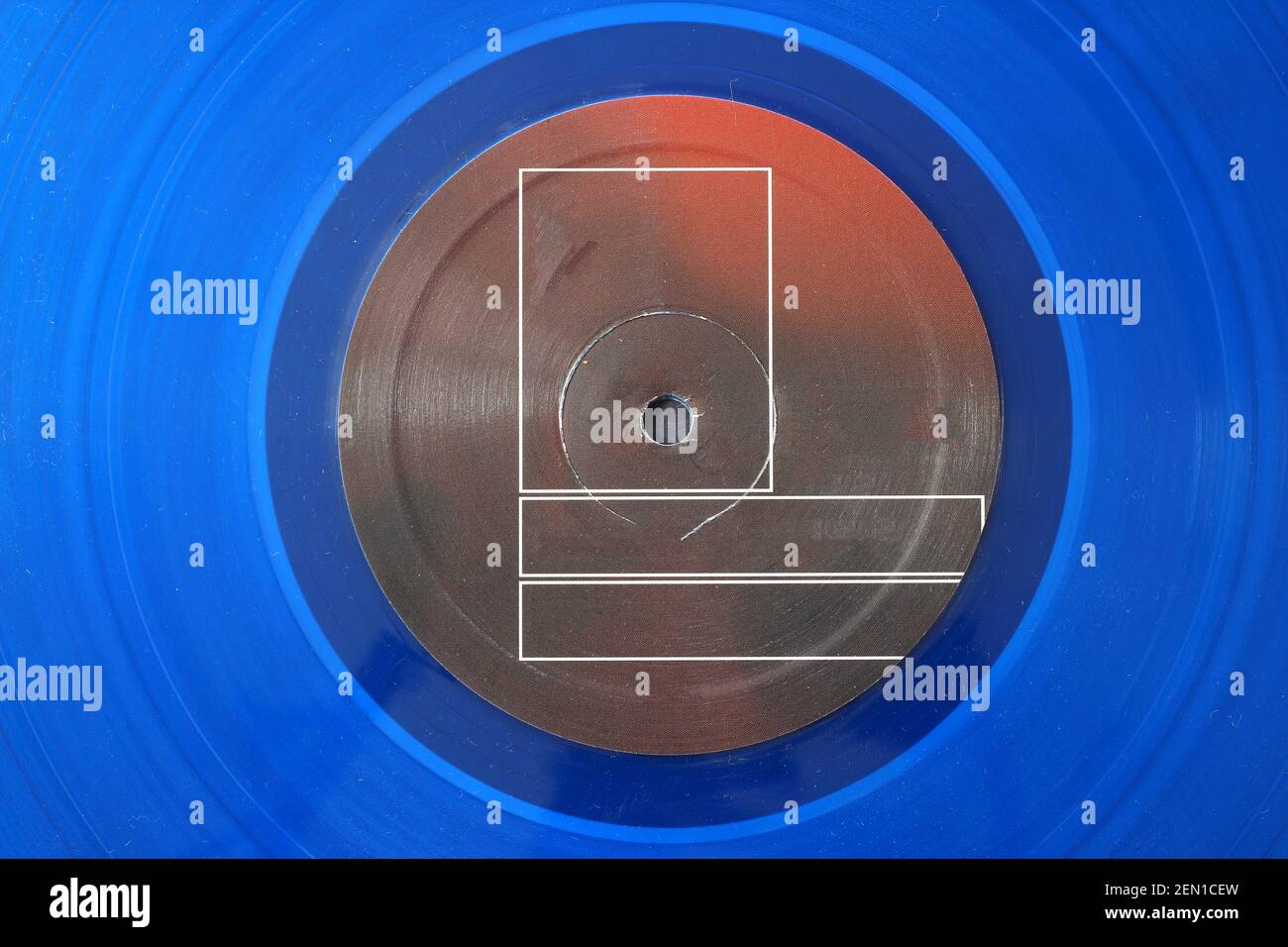 12-inch LP vinyl record disk with blank red label. Close-up shot, top ...