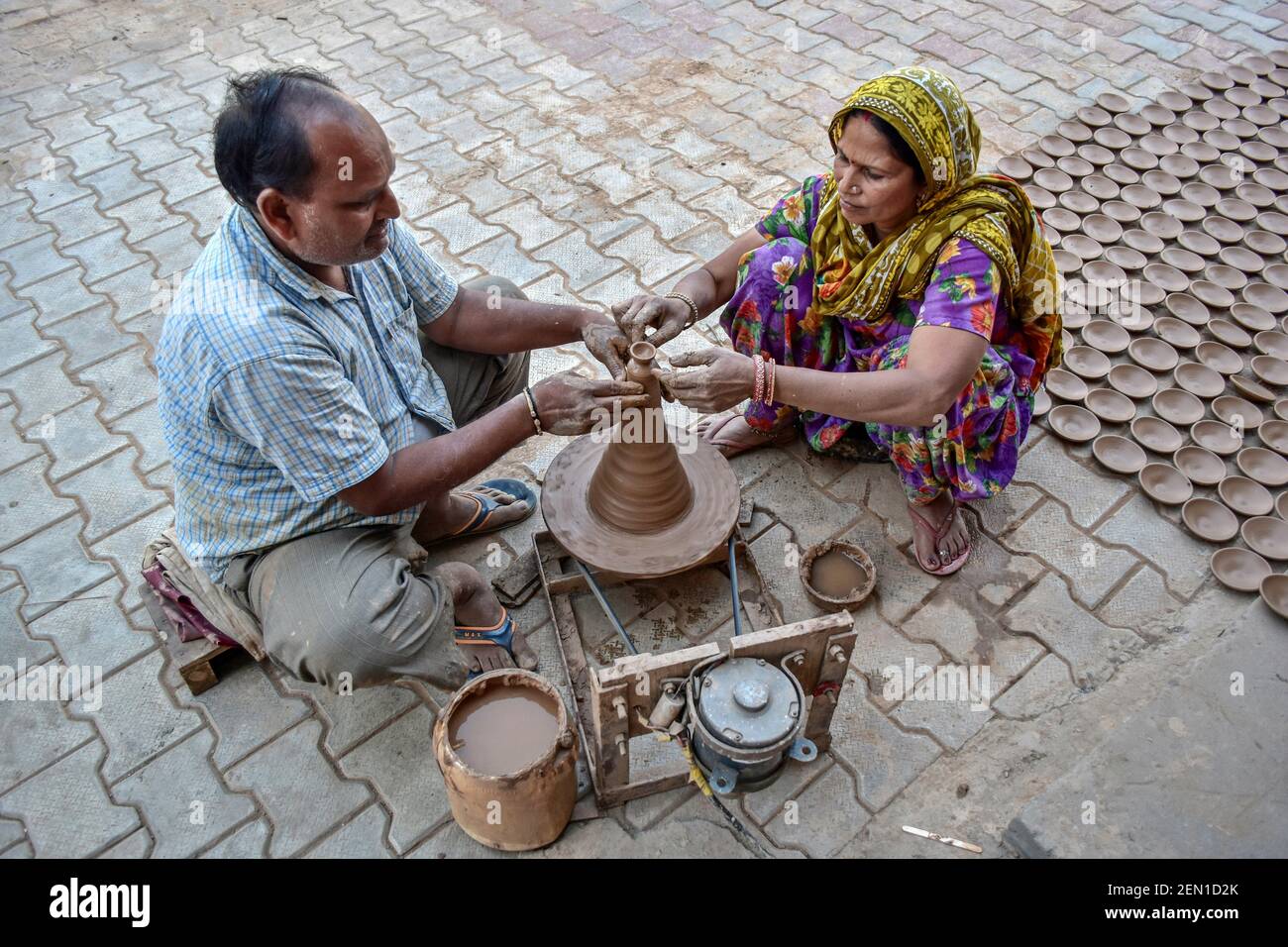 Indian potters are seen making traditional earthen pots and lamps in ...