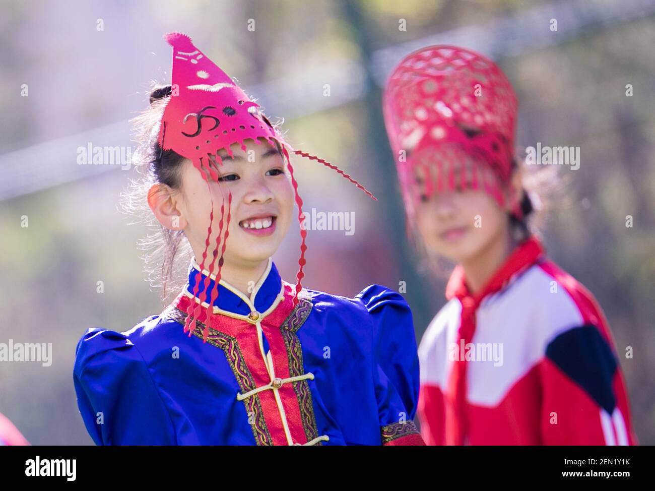 Chinese primary students dressed in traditional costumes and wearing ...