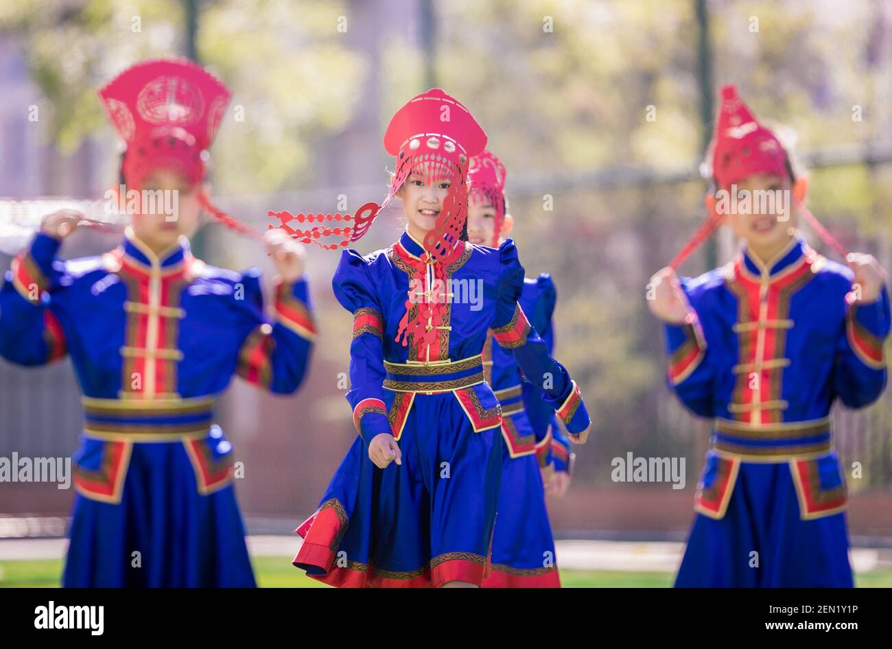 Chinese primary students dressed in traditional costumes and wearing ...