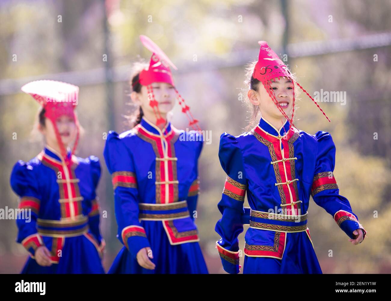 Chinese primary students dressed in traditional costumes and wearing ...