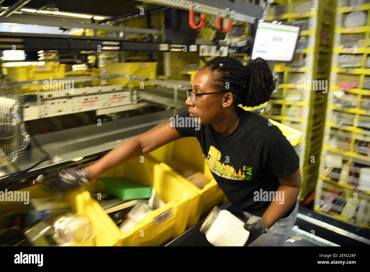 Jackie Spence places ordered products into bins in the Amazon's BWI2 ...