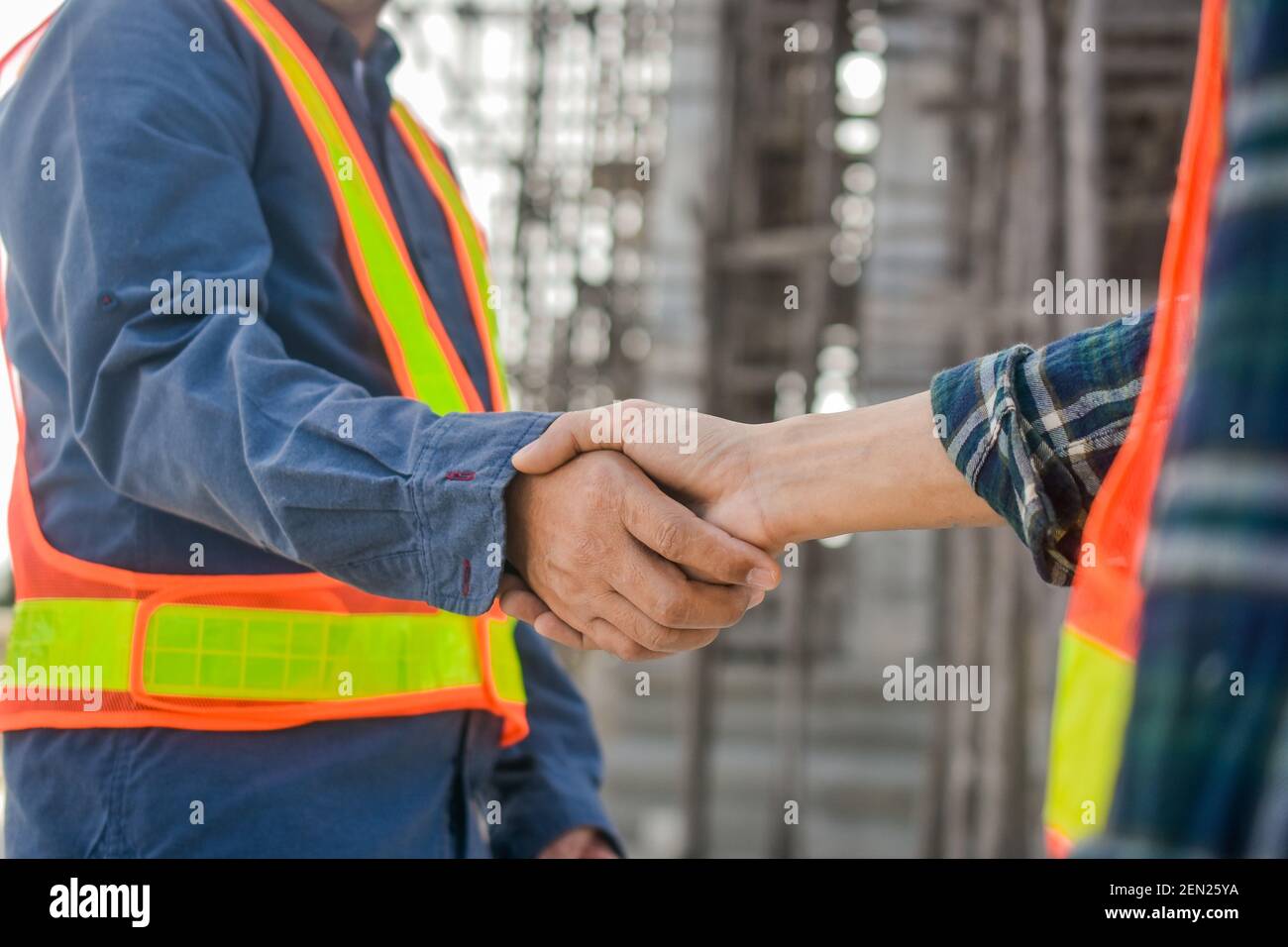 Two Engineer shake hand agreement success project at construction site ...