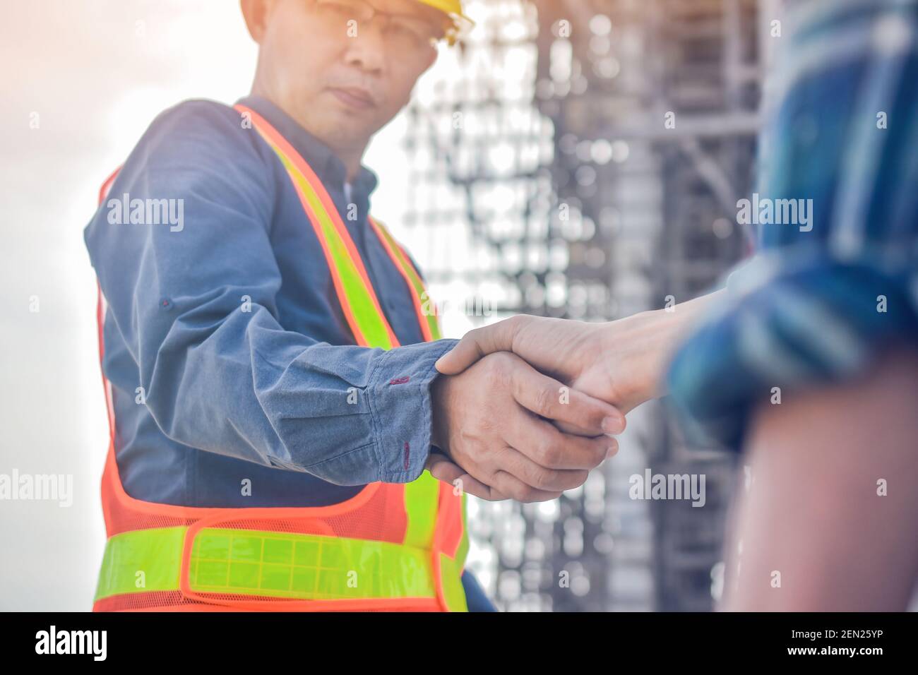 Two Engineer shake hand agreement success project at construction site ...