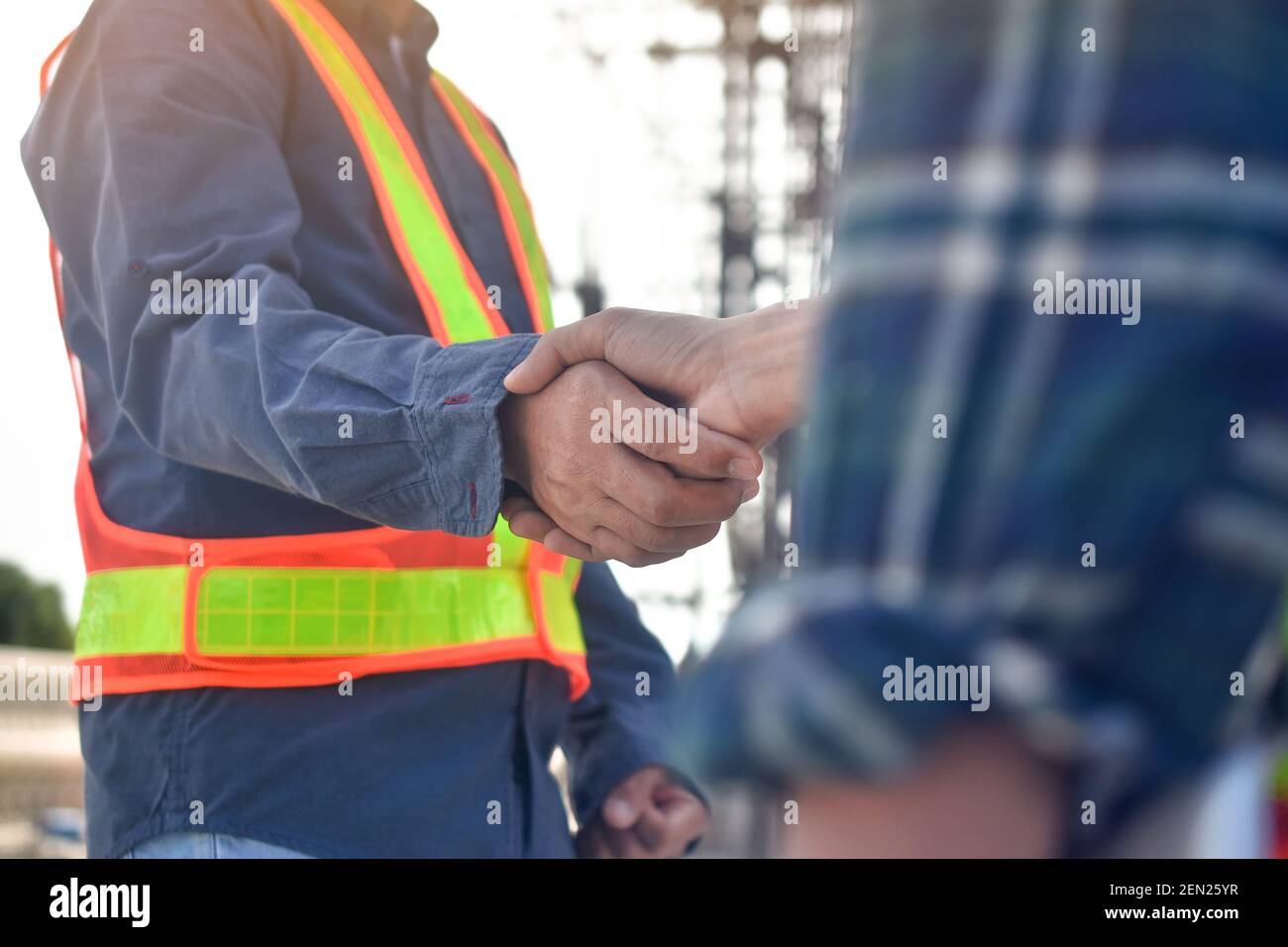 Two Engineer shake hand agreement success project at construction site ...