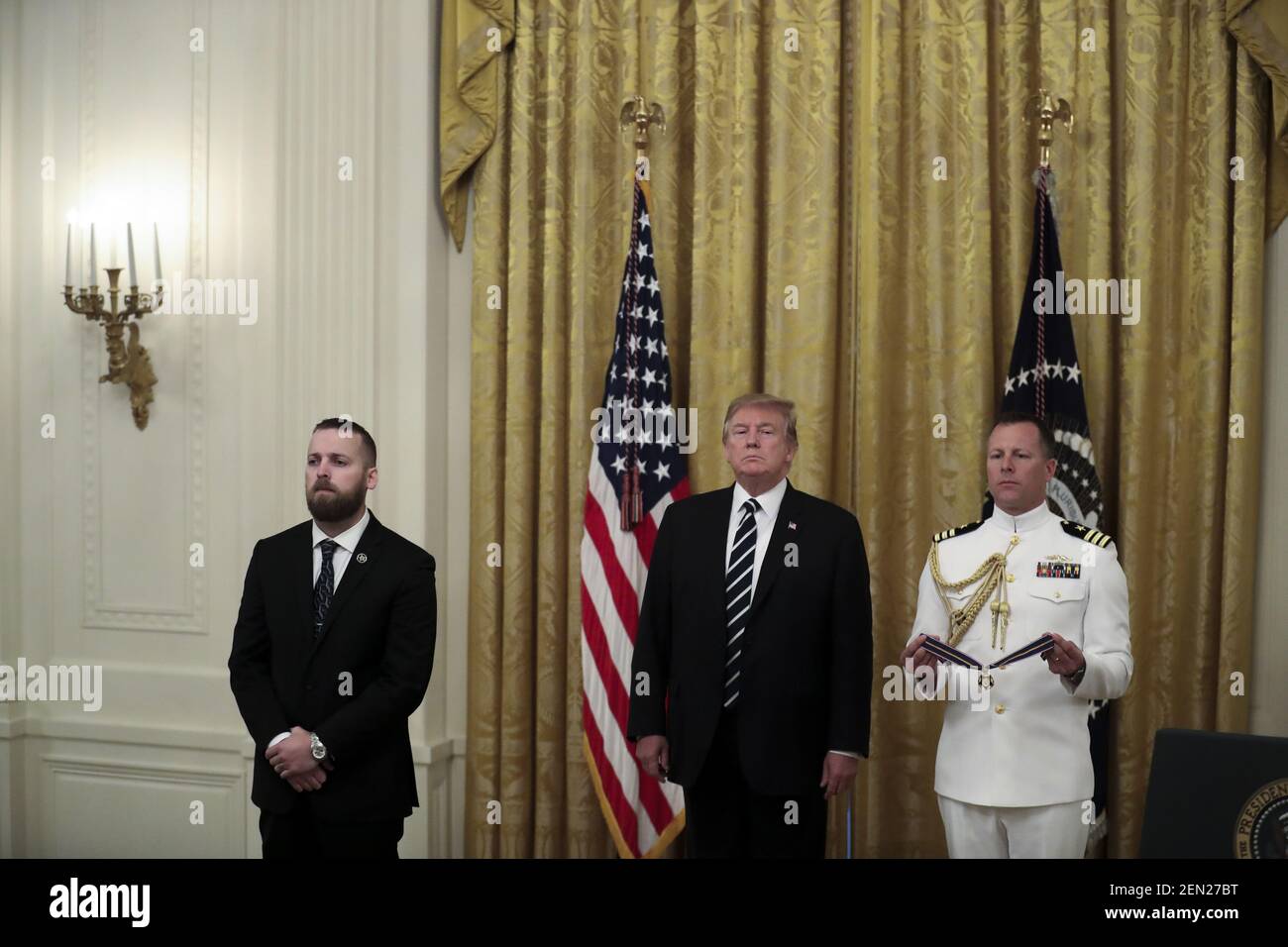President Donald Trump, center, listens the citation before presenting ...