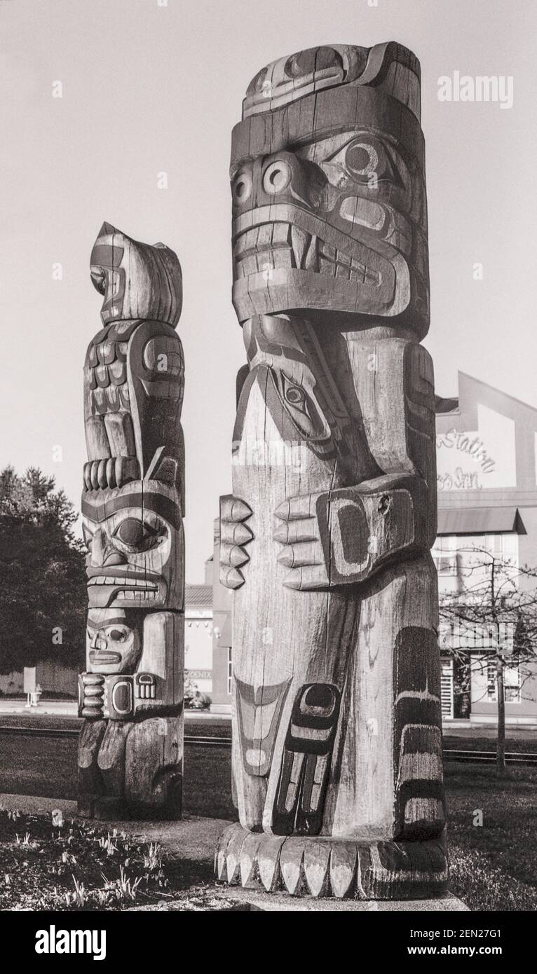 two totem poles within an urban setting Stock Photo - Alamy
