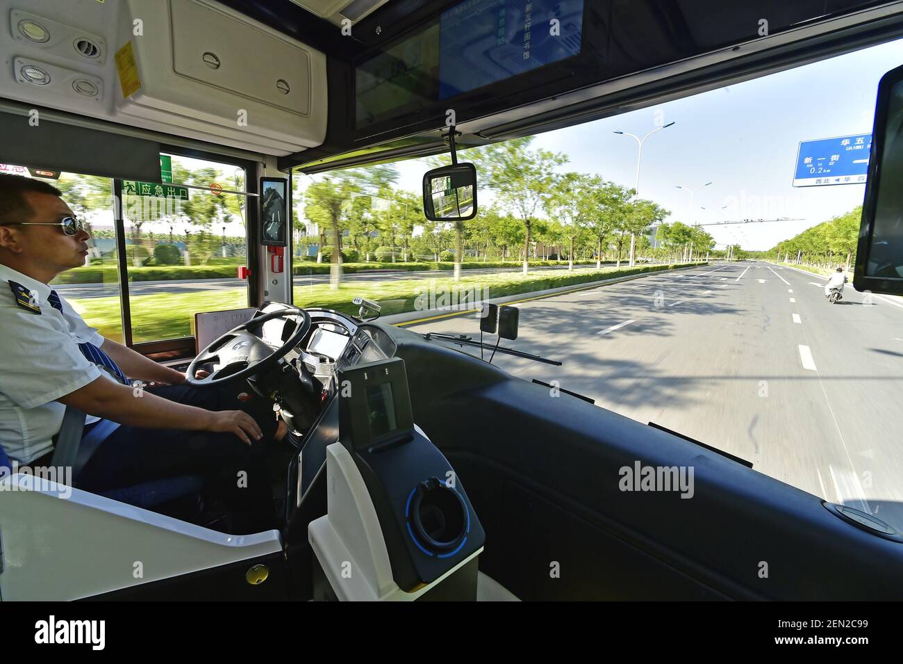 A driver operates a multi-functional AI-based autonomous driving bus ...