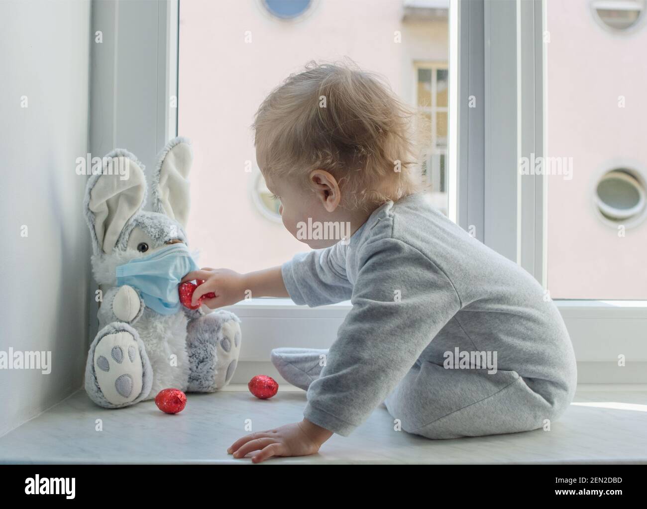 Easter 2021 concept with child in home quarantine playing at the window ...
