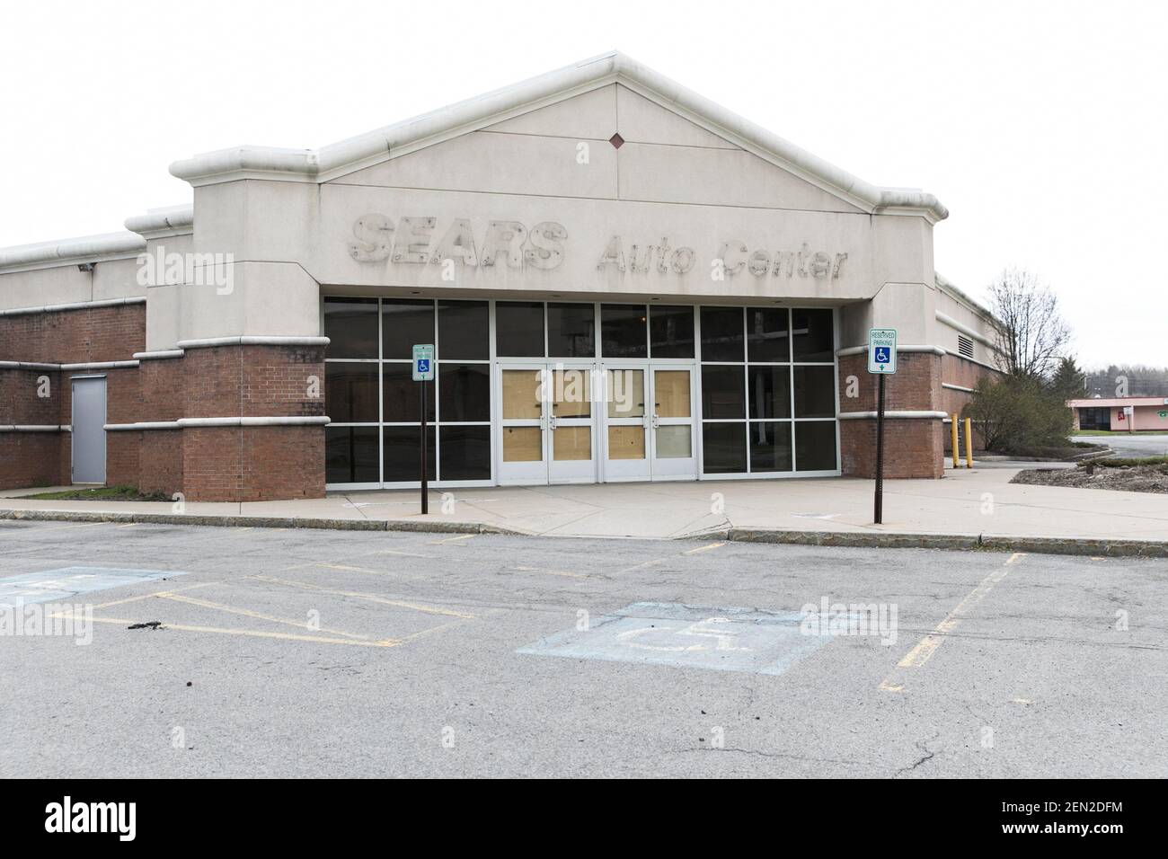 The outline of a Sears Auto Center logo sign outside of a closed retail ...