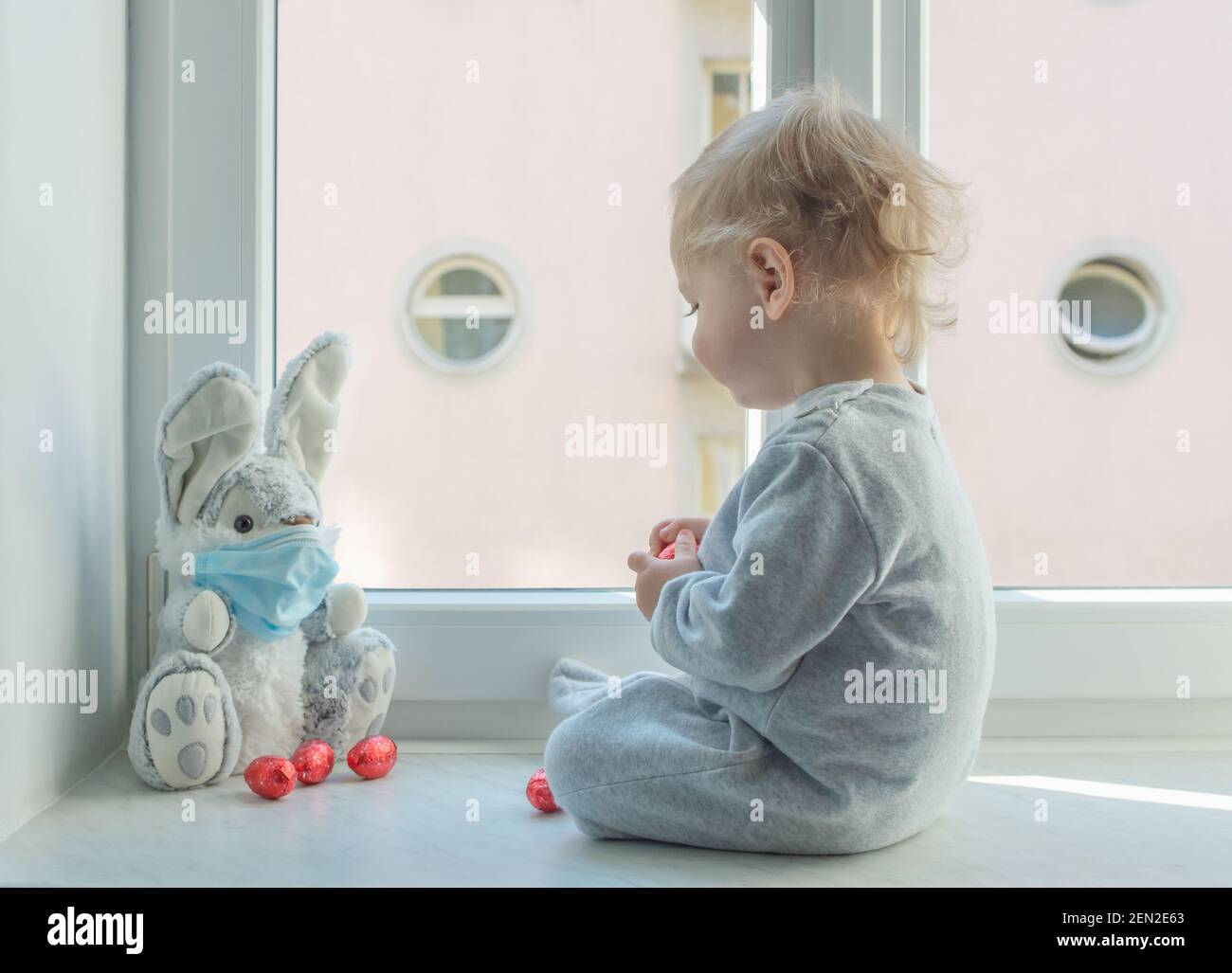 Easter 2021 concept with child in home quarantine playing at the window ...