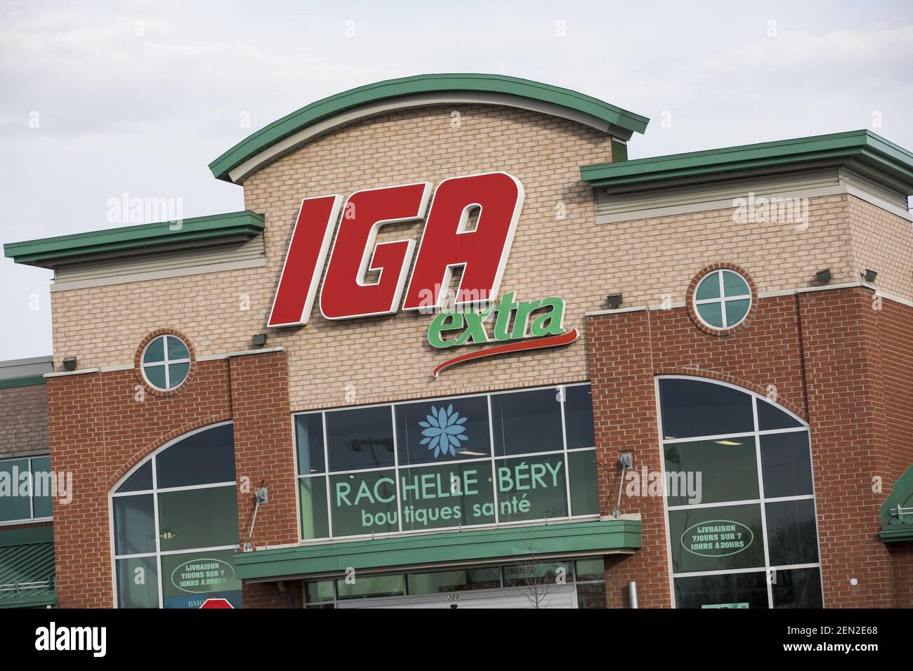 A logo sign outside of a IGA retail grocery store location in ...