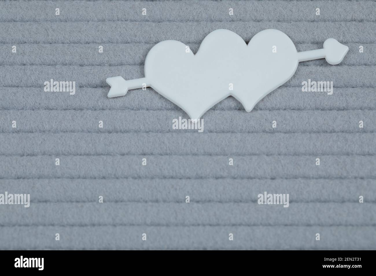 Crossing hearts embedded on grey background Stock Photo - Alamy