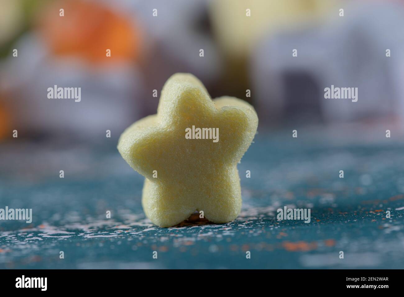 A yellow star shape marshmallow on the ground Stock Photo - Alamy
