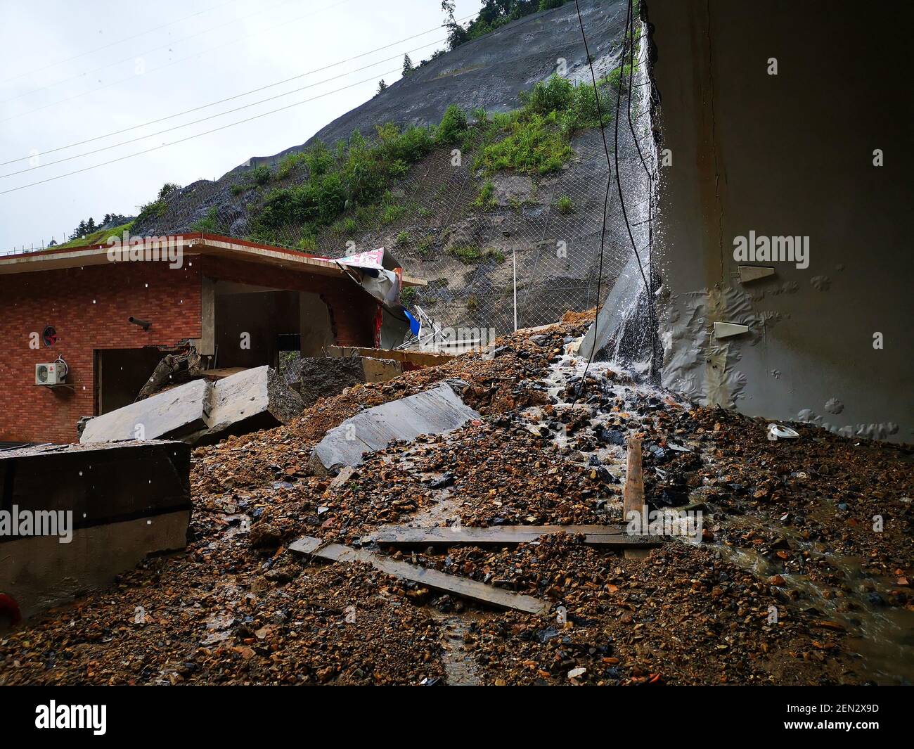 Chinese workers clear away mud and stones after the Jindong Tunnel on ...