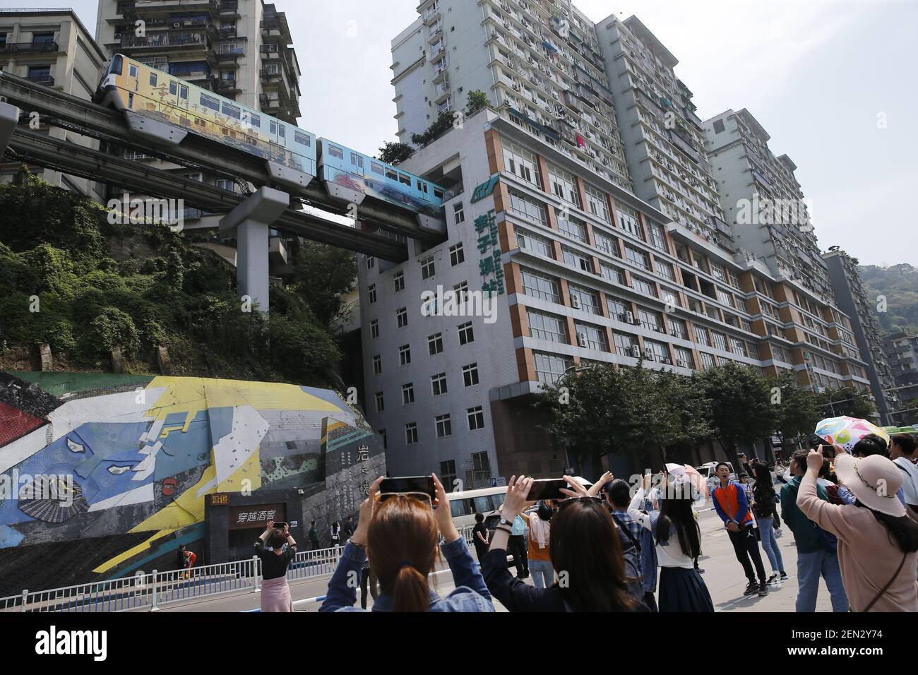 --FILE--People take pictures or videos of a monorail train driving into ...