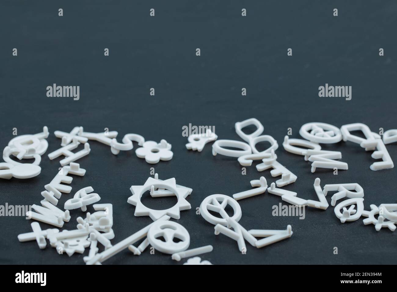 Detachable white color letters, icons and pins on black background ...