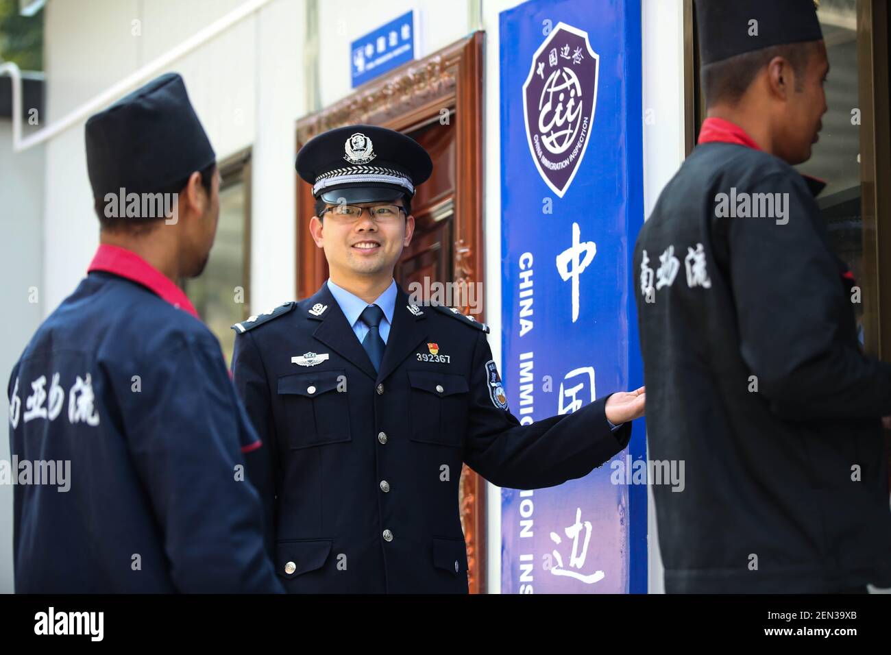 A Chinese police officer directs Nepalese logistics workers into the ...