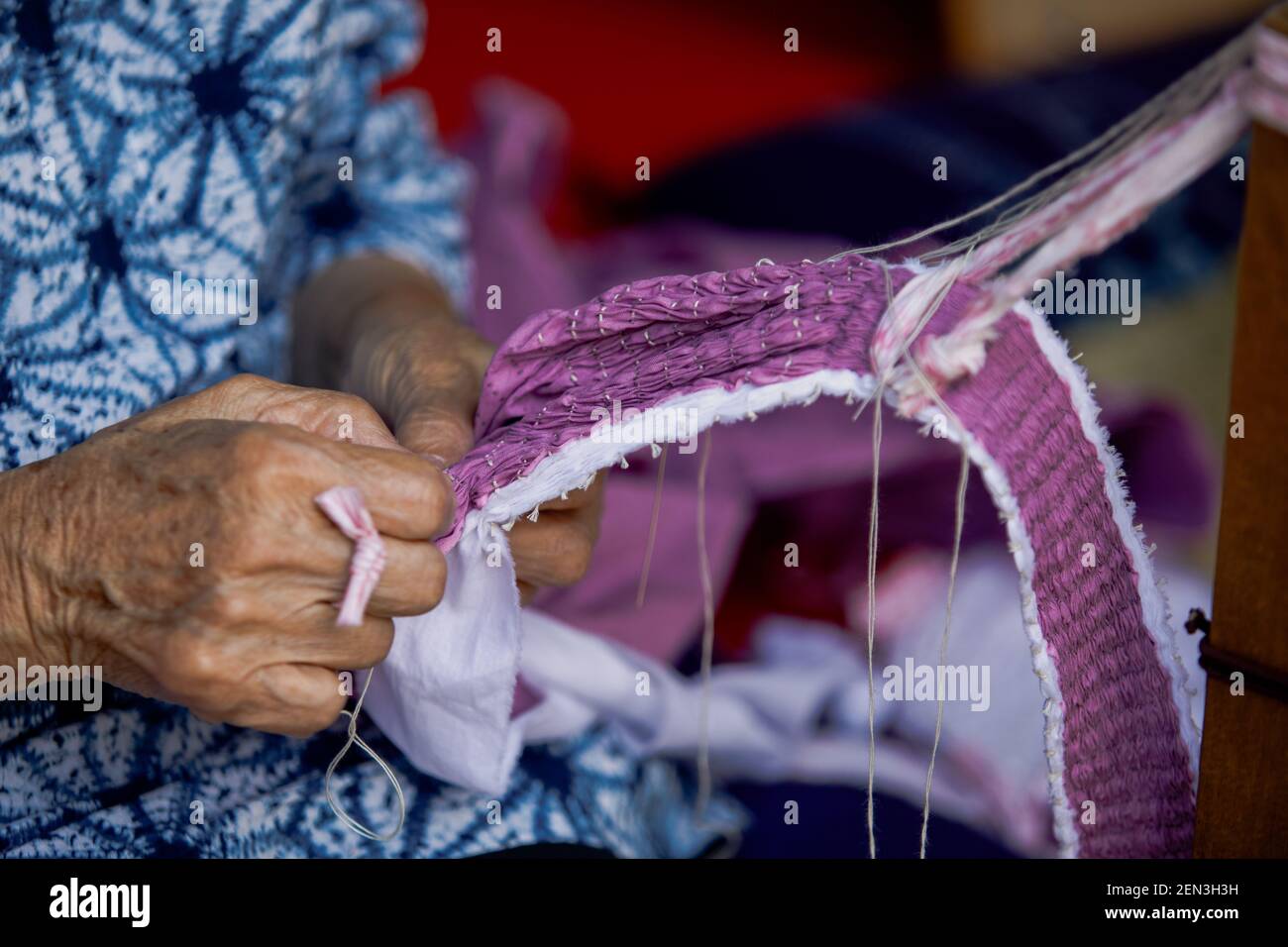 A craftsman sewing a piece of cloth during a festival centred around ...