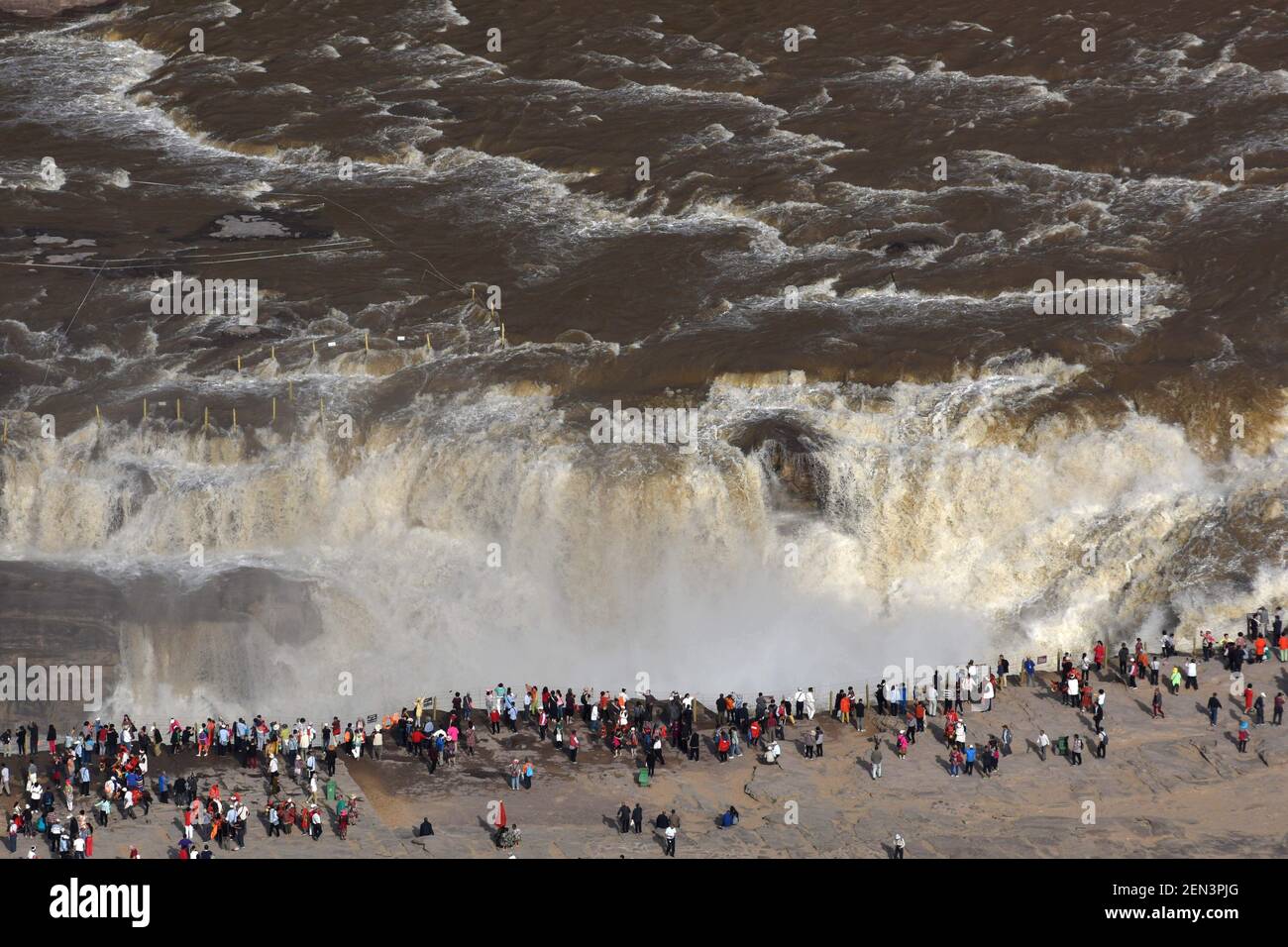 Tourists visit the roaring Hukou Waterfall on the Yellow River after ...