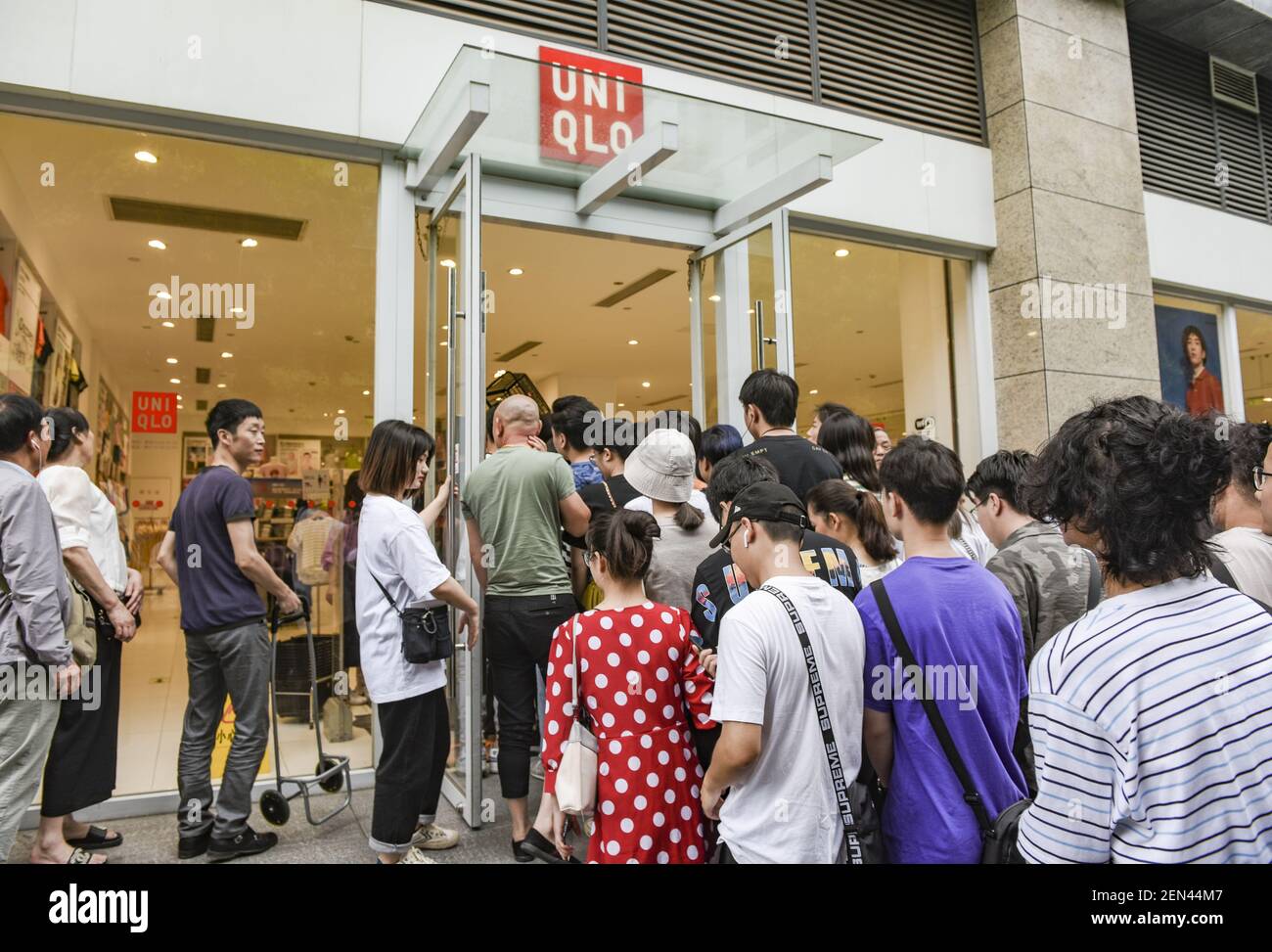 Chinese customers queue up in front of a Uniqlo store to buy the ...