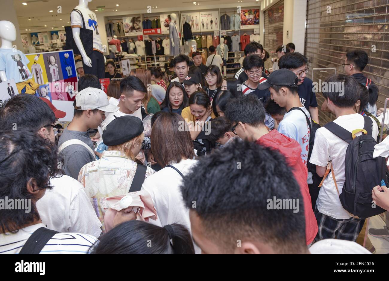 Chinese customers queue up in front of a Uniqlo store to buy the ...