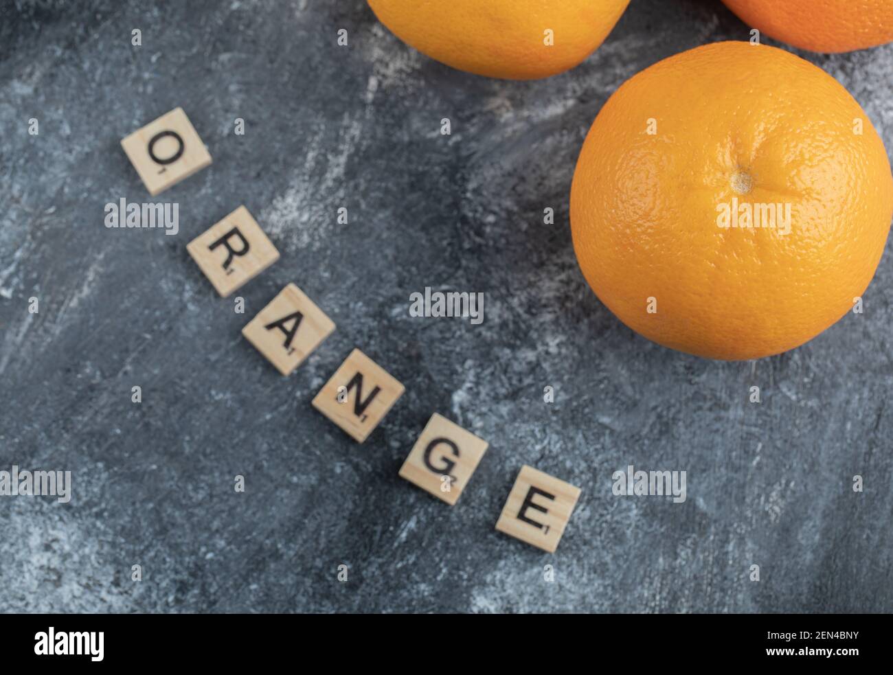 Oranges and wooden letters spelled as orange on marble background Stock ...