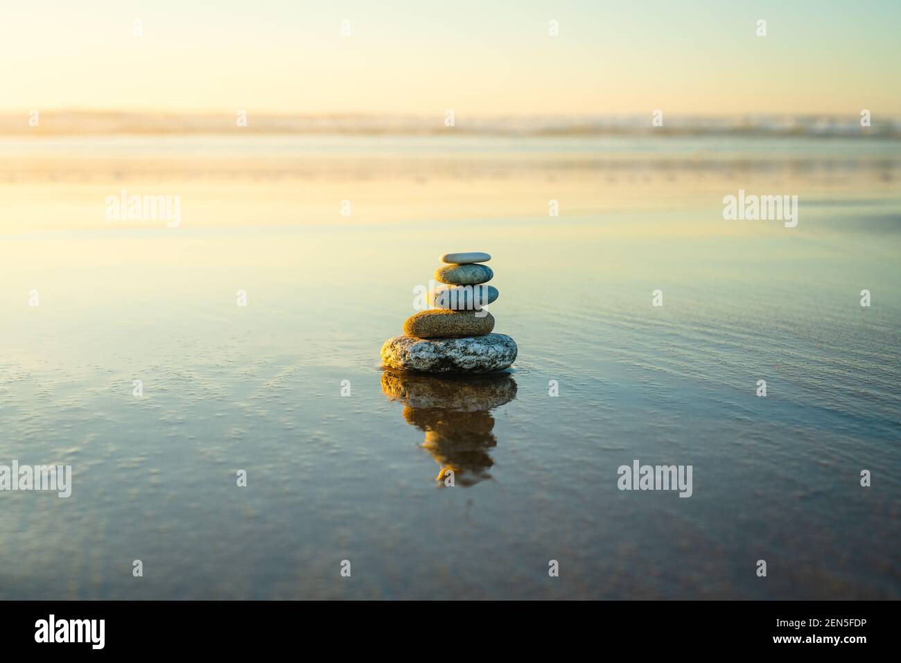 Pyramid of stones on the beach at sunset. Tranquil scene, relaxation ...