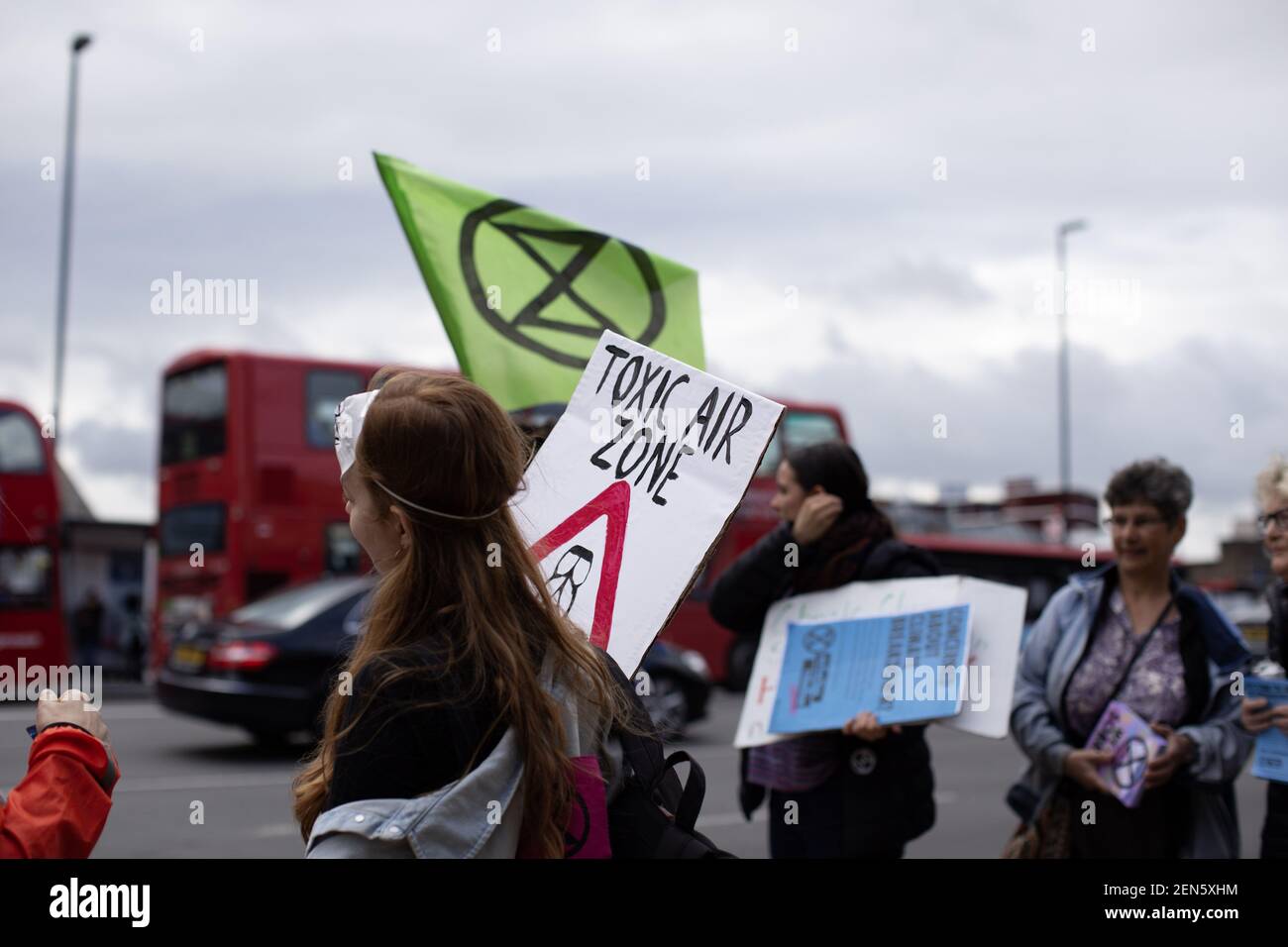 A protester holds up a 'toxic air zone' placard during a protest ...
