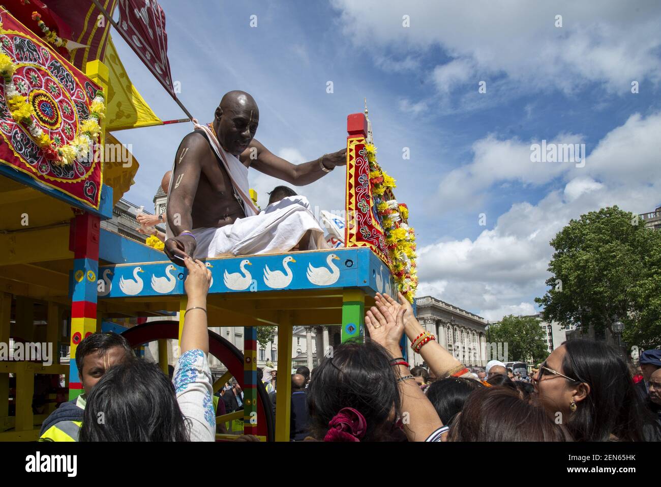A priest gives devotees and pilgrims a flower gift to bring life ...