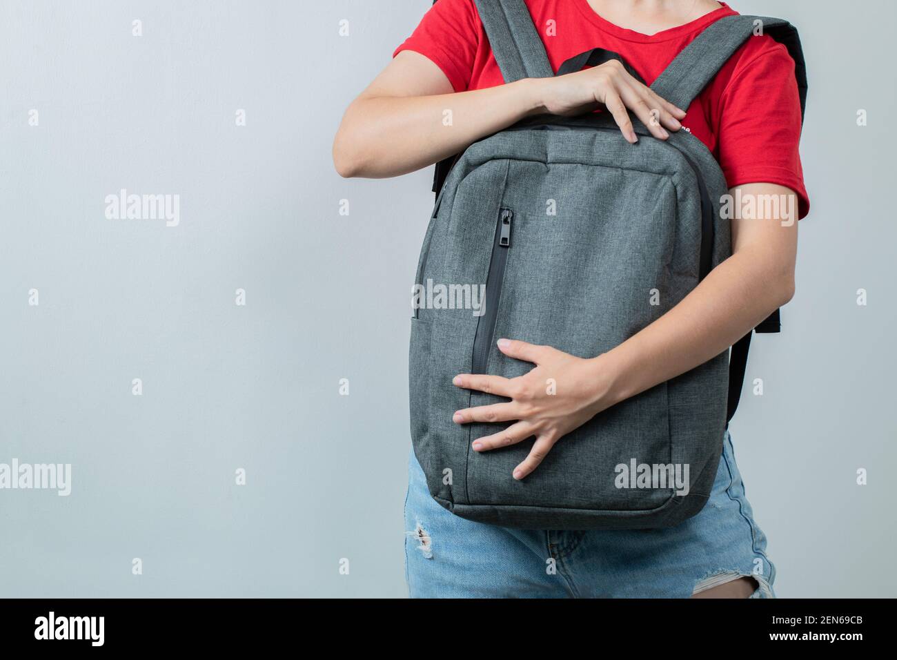 Student holding the grey backpack in the front Stock Photo - Alamy