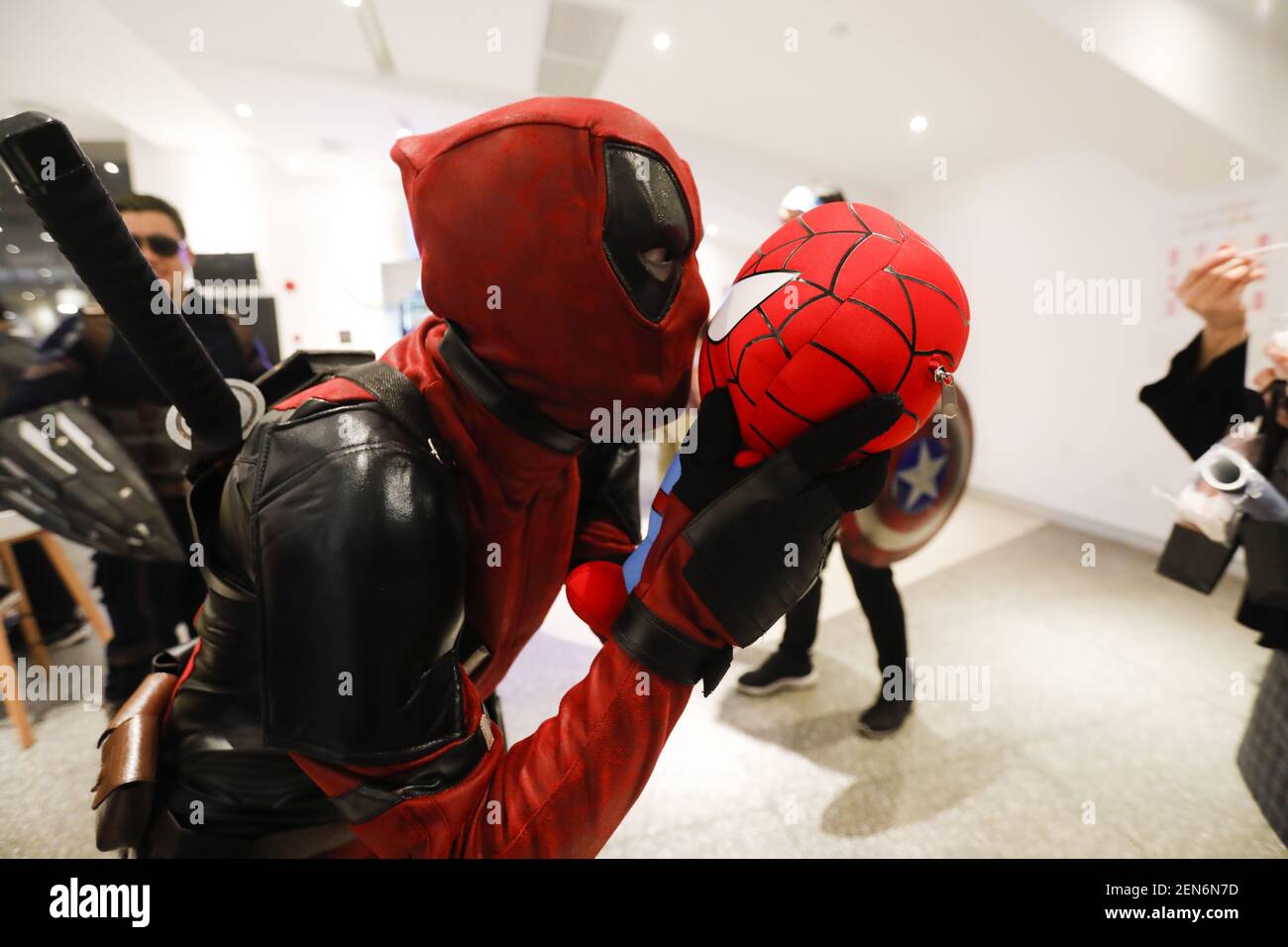 A Chinese filmgoer wearing costume of Deadpool waits inside a cinema ...
