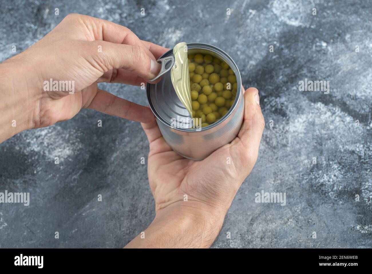Man trying to open tin. Green olives Stock Photo - Alamy