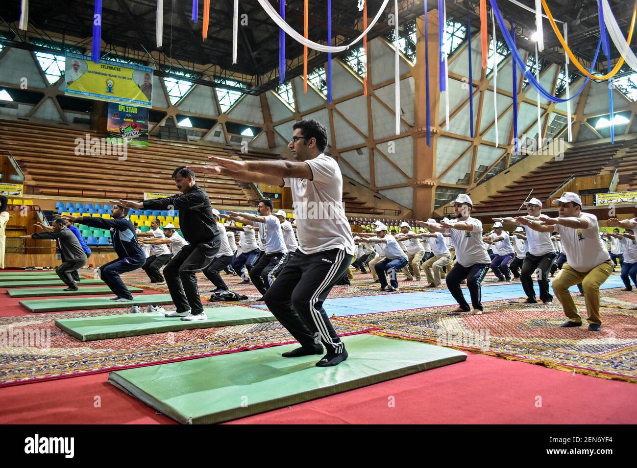 Participants perform yoga during a mass yoga session on International ...