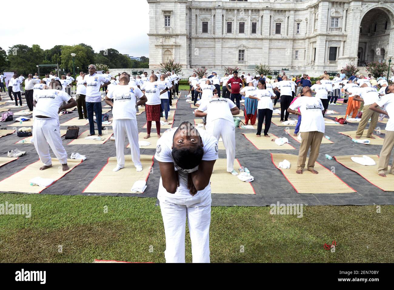 People perform yoga in front of Victoria Memorial on the occasion of ...