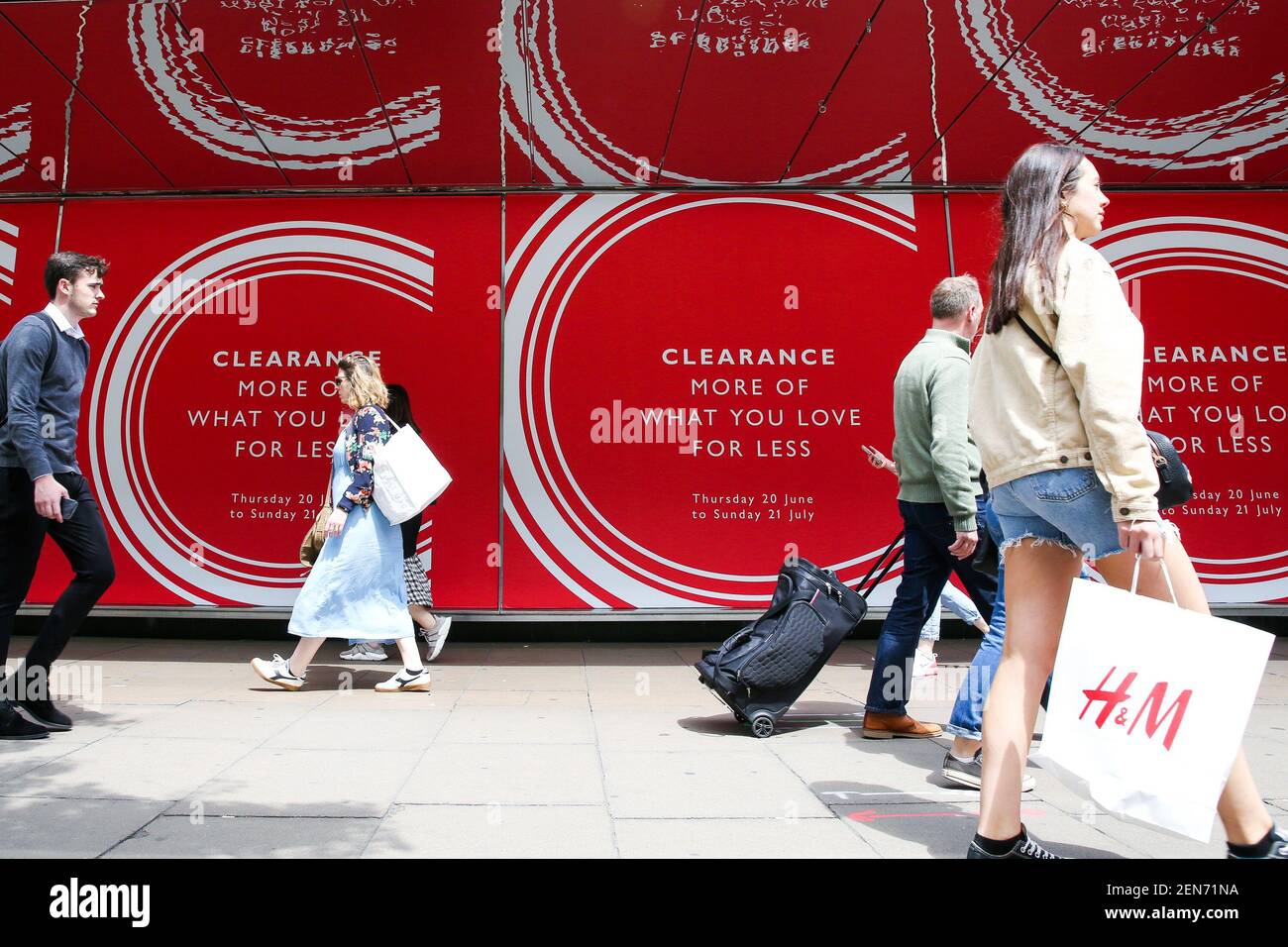Shoppers walk past a store window display on Oxford Street as summer ...