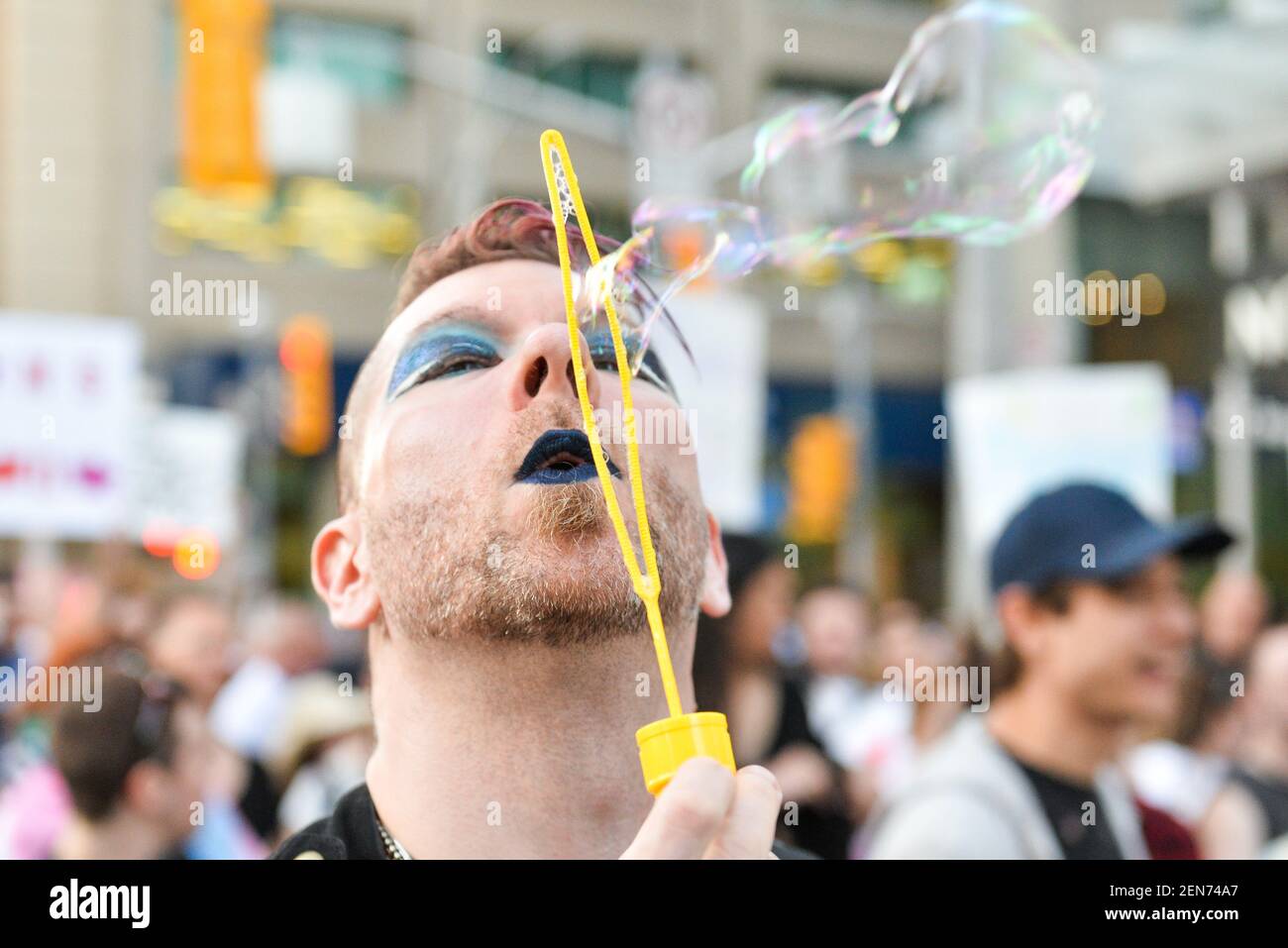A protester blows soap bubbles during the Trans march. Spectators ...