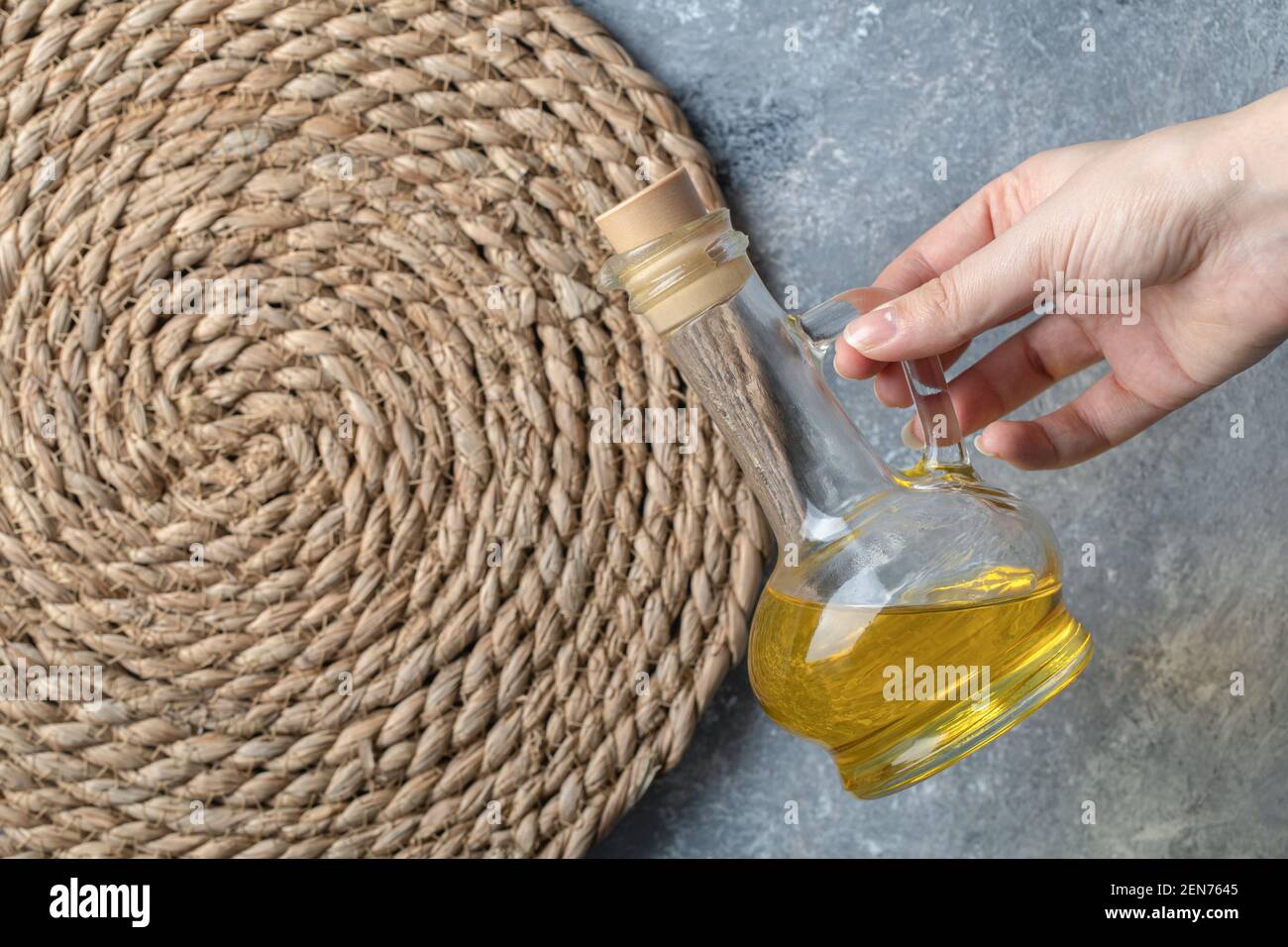 Female hand holding bottle of oil Stock Photo - Alamy