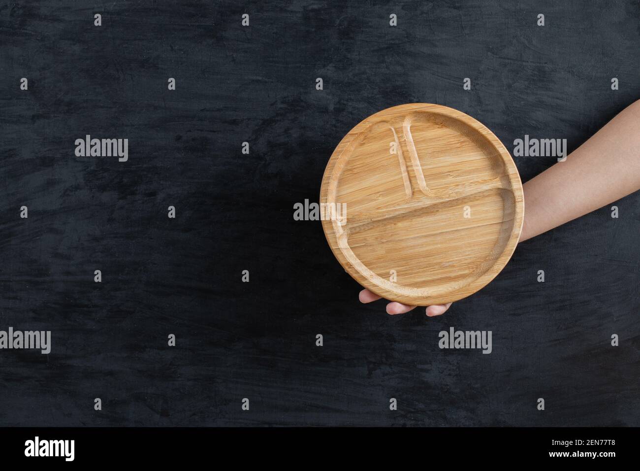 Holding a round wooden platter in the hand Stock Photo - Alamy