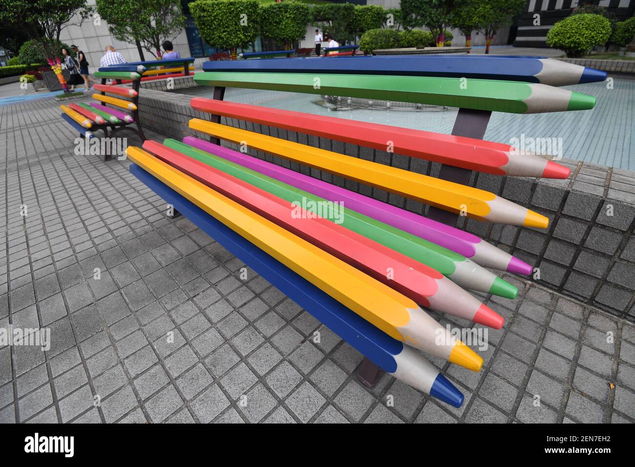 Colored pencil benches are pictured at a square amongst office ...