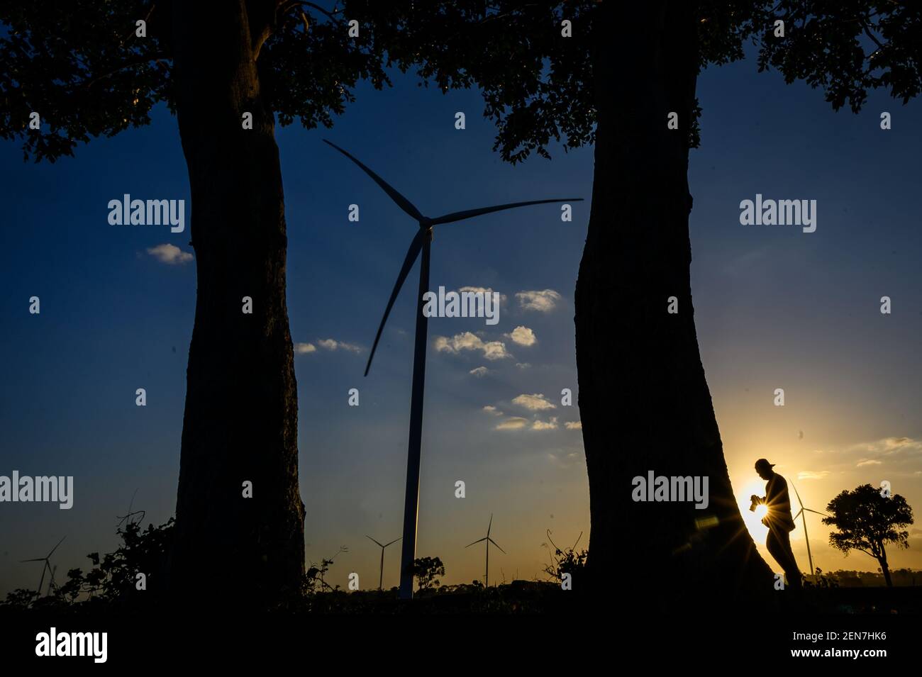 A resident walks past the turbines on Tolo 1Jeneponto wind energy power ...