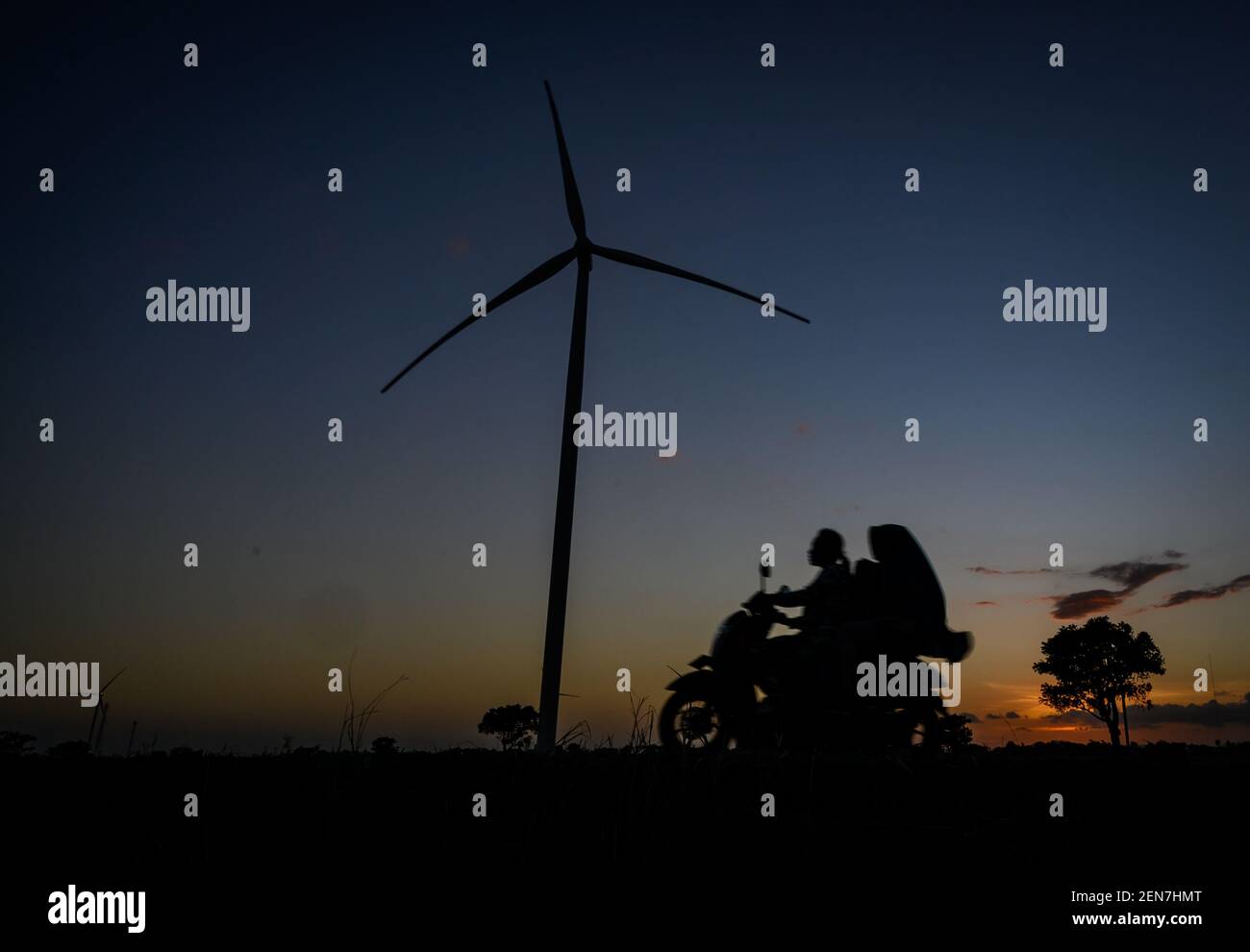 Residents ride past the turbines on Tolo 1Jeneponto wind energy power ...