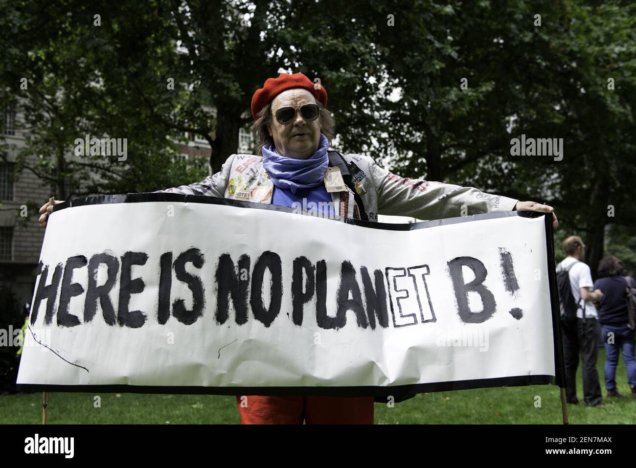 An Environmental protester holds a banner that says Here is no planet B ...