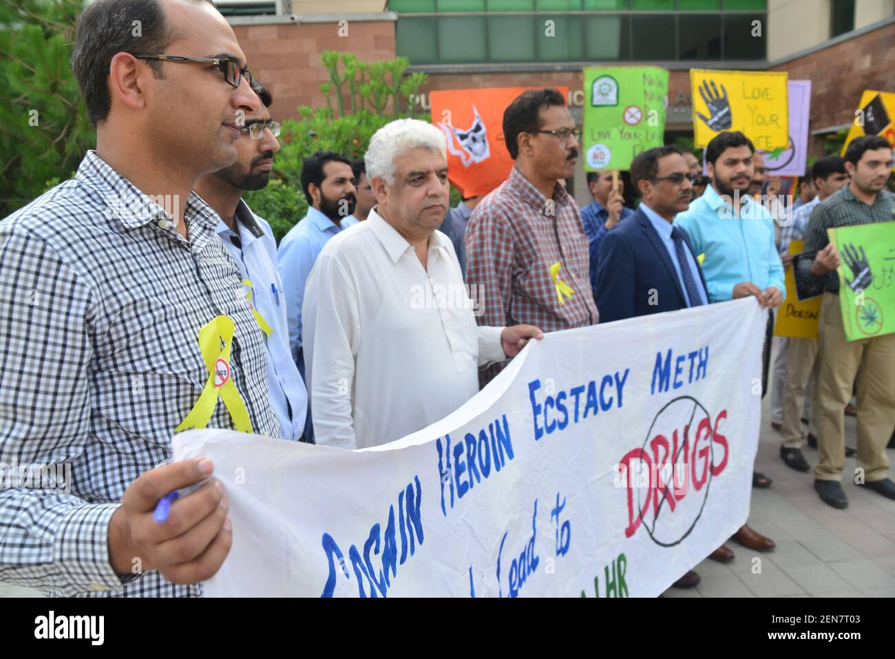 Members and officers of Punjab Forensic Science Agency hold banners ...