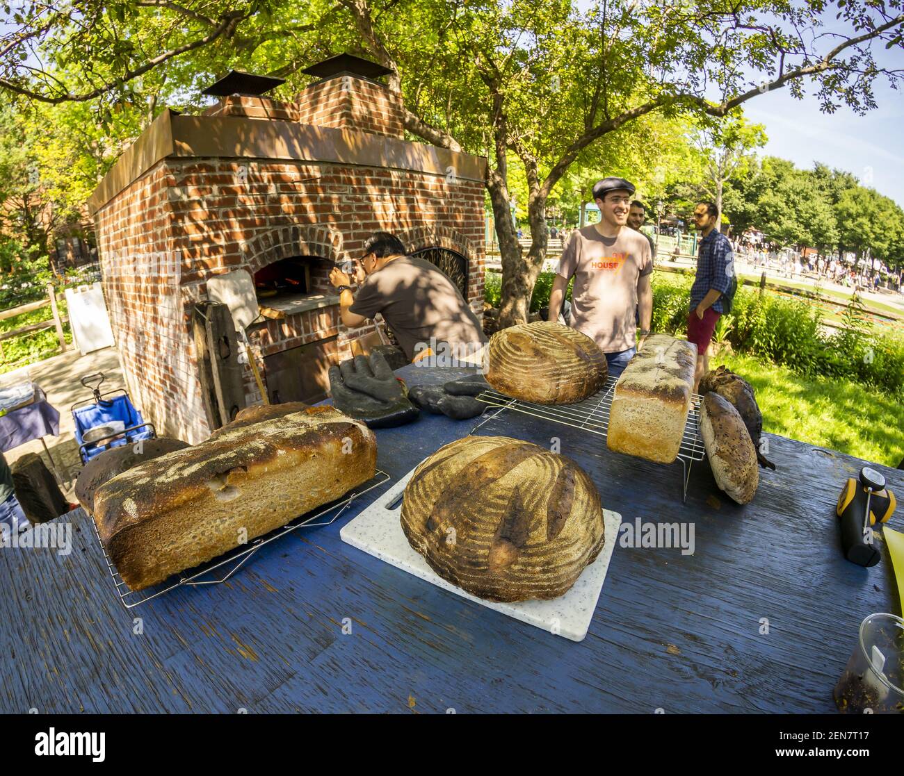 Bakers gather around a wood-fired brick oven on Sunday, June 23, 2019 ...