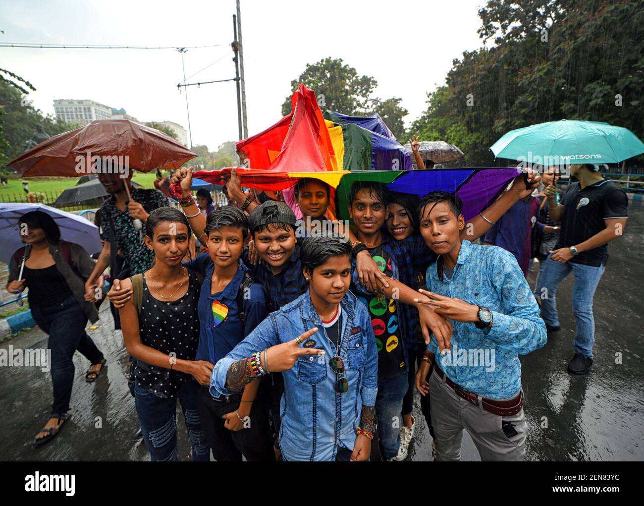LGBT Community members seen walking with a large LGBT flag under heavy ...