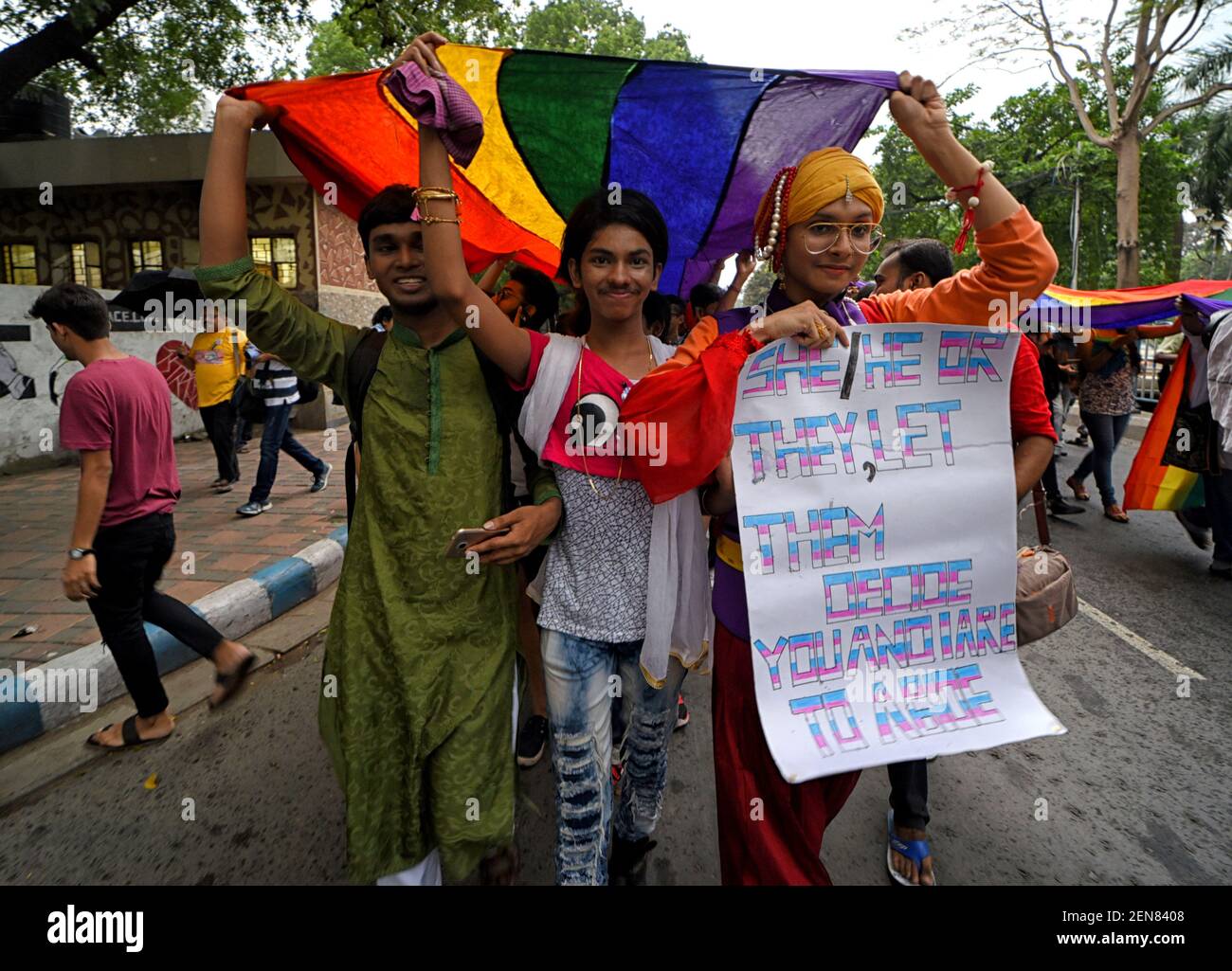 LGBT Community members seen walking with a large LGBT flag under heavy ...